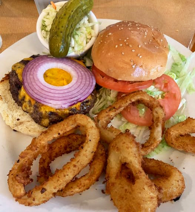 This isn't just a burger—it's architecture. The perfect stack of beef, cheese, and fresh toppings with onion rings standing guard.