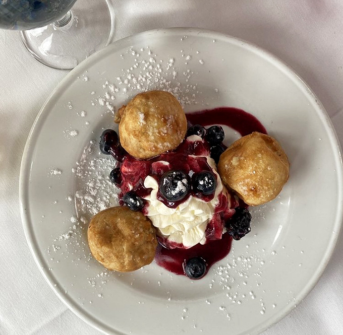 Dessert nirvana: golden beignets surrounding a berry-crowned cloud of cream &ndash; proof that heaven might actually be a place on earth.