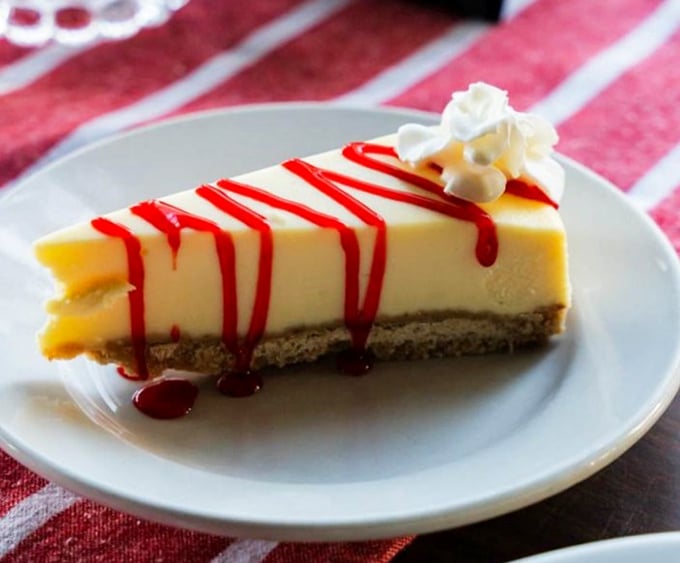 Cheesecake with raspberry drizzle that makes you wonder if dessert should actually be the main course of every meal.