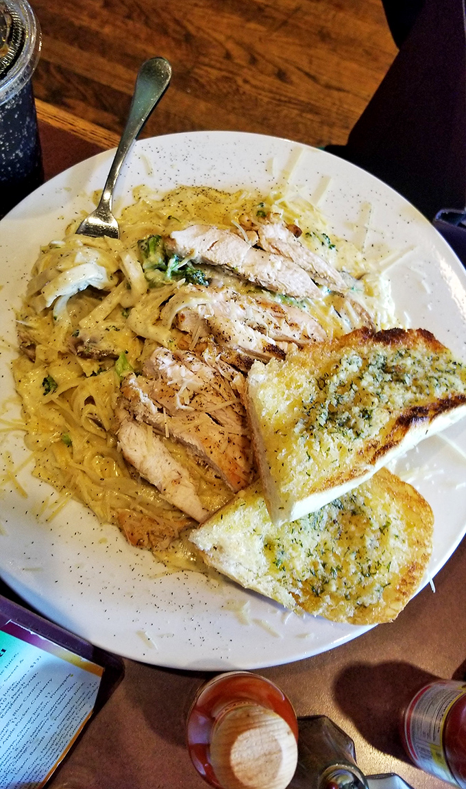 Pasta perfection with grilled chicken that makes you wonder if this is what angels eat on their lunch break. That garlic bread deserves its own fan club.