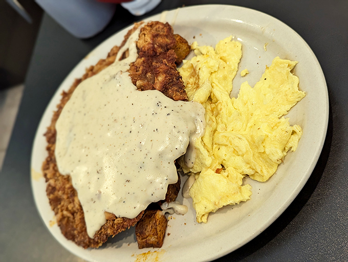 Chicken fried steak with gravy cascading over the edges &ndash; Texas on a plate, with eggs playing a sunny supporting role.