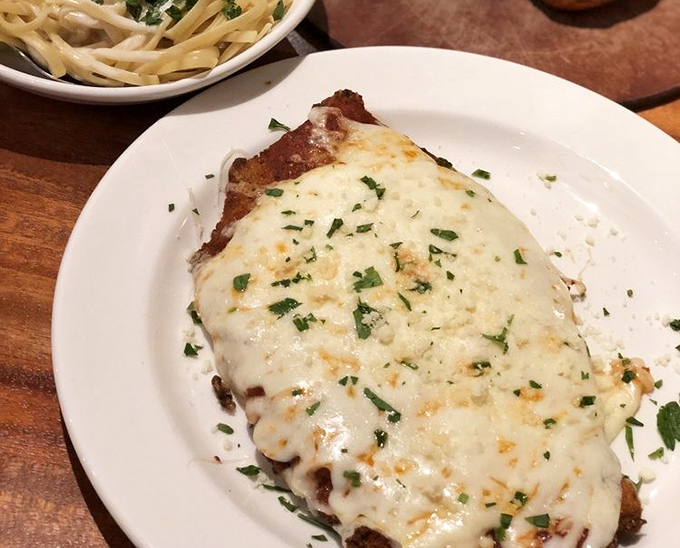 Chicken parmesan that doesn't know the meaning of "portion control." That golden cheese blanket is what comfort food dreams are made of.