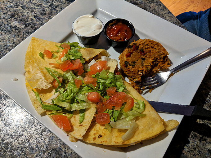 Not just any quesadilla—this golden-crisp creation comes with a side of what appears to be Spanish rice and pure joy.