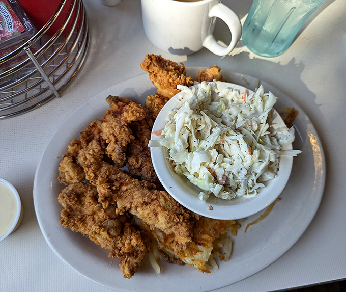 Crispy on the outside, tender on the inside—these chicken tenders aren't just food, they're an argument against growing up. The coleslaw provides the perfect cool counterpoint.