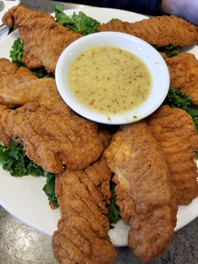 Golden-fried chicken tenders that crunch louder than your dad in a quiet movie theater, served with honey mustard for dunking perfection.