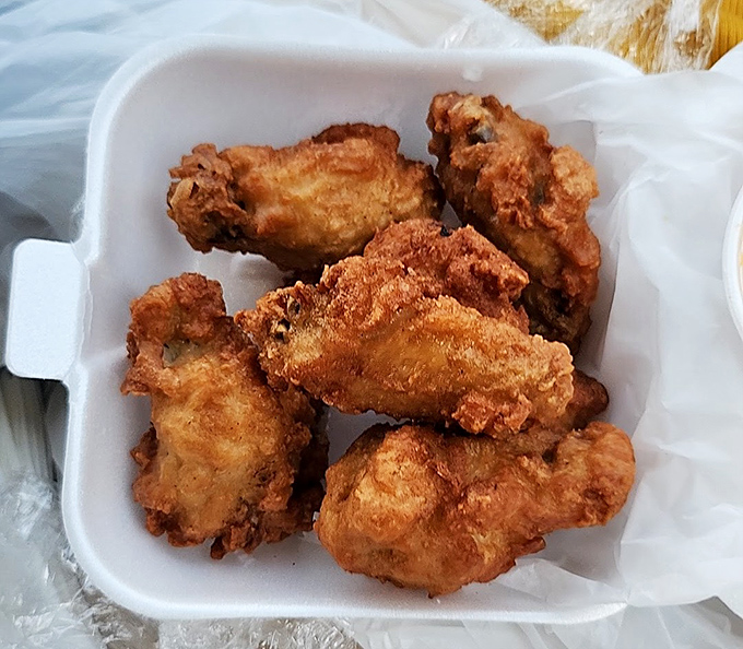 Fried chicken wings with that perfect golden crunch &ndash; the kind that announces their arrival with a symphony of crackling sounds.