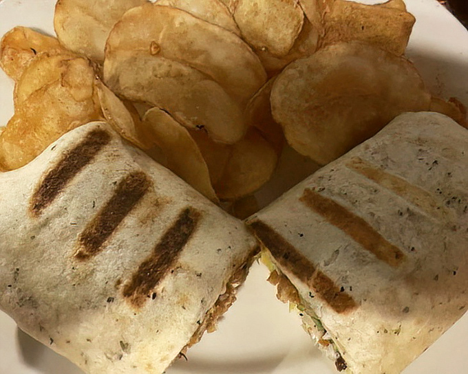 Simple pleasures done right&mdash;a grilled wrap cut to reveal its treasures inside, paired with homemade potato chips that shatter with each bite.