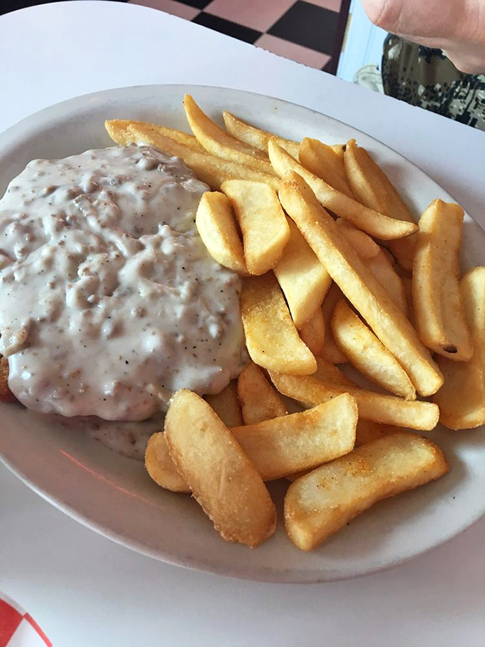 Country gravy cascading over golden fries like a comfort food waterfall. This plate doesn't just feed your hunger&mdash;it hugs your soul.