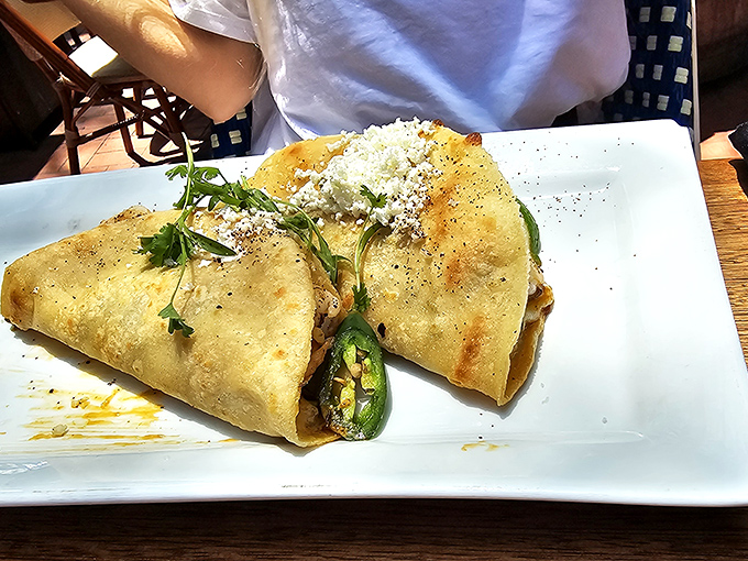 Two perfectly grilled quesadillas with a sliced jalape&ntilde;o standing guard&mdash;a simple presentation that belies the flavor explosion waiting inside.