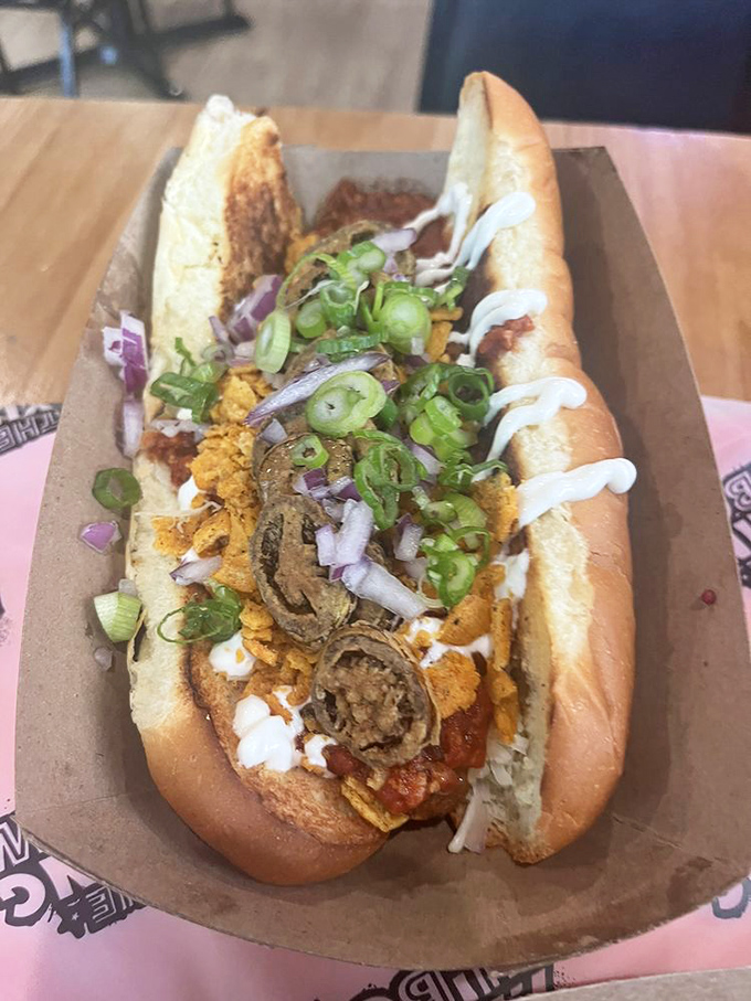 This loaded hot dog doesn't just bring toppings to the table; it brings an entire flavor entourage—crisp vegetables, savory sauce, and a bun that cradles it all perfectly.