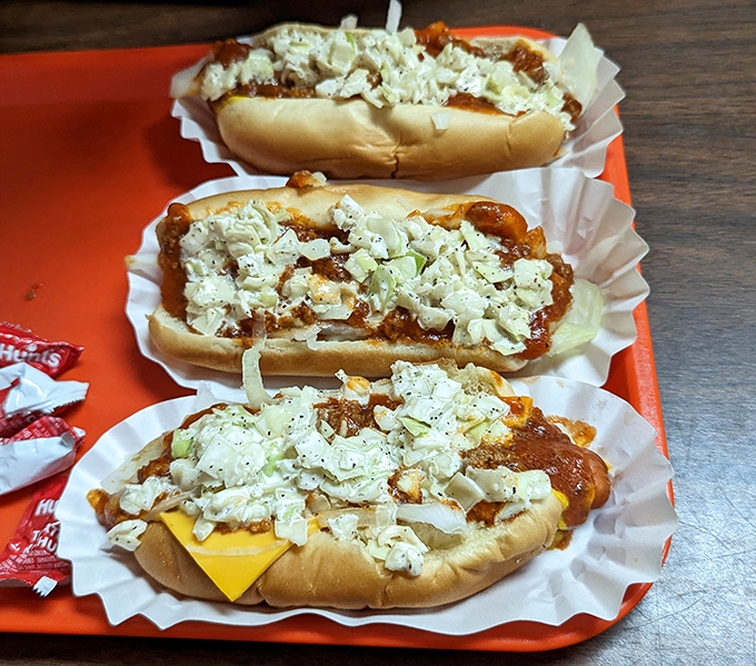 Hot dogs elevated to an art form with chili and slaw piled high. The kind of messy masterpiece that requires strategic napkin deployment and zero concern for dignity.