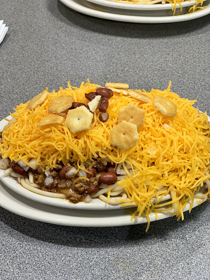 The legendary five-way in all its glory: a mountain of shredded cheddar blanketing chili-drenched spaghetti with beans and onions playing hide-and-seek below.