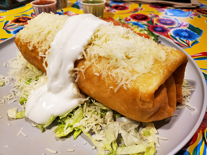 Golden-fried perfection topped with a snowfall of cheese and fresh veggies—the chimichanga that launched a thousand cravings.