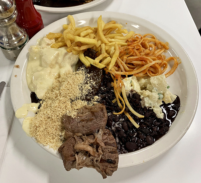 The Brazilian approach to a balanced meal: black beans, rice, farofa, and enough protein to fuel a marathon. Deliciously unapologetic.