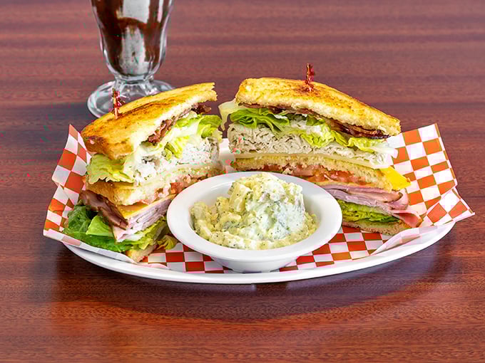 The club sandwich: three stories of delicious architecture that requires both hands and absolutely no shame. Potato salad as the perfect sidekick.