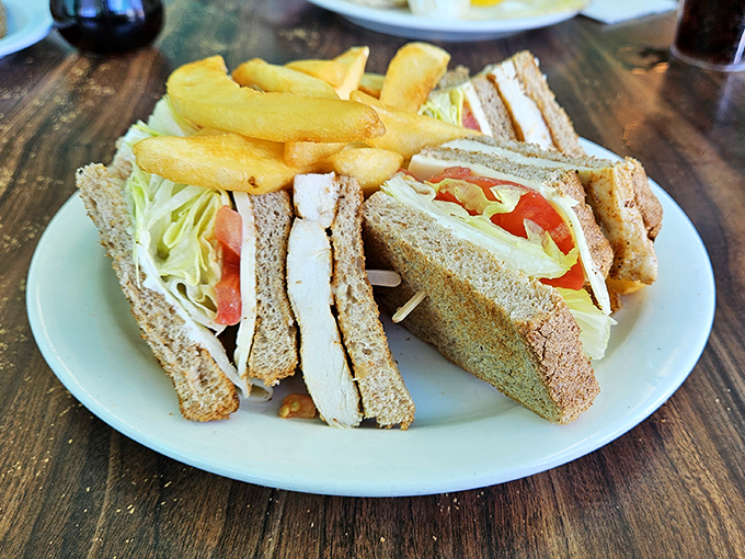 A club sandwich that remembers what sandwiches are supposed to be: substantial, straightforward, and served with fries that actually taste like potatoes.