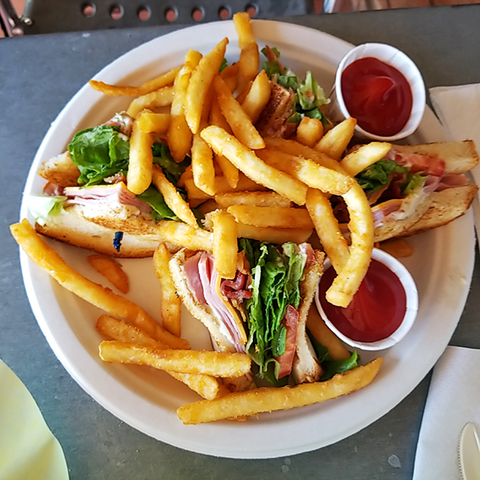 This club sandwich stands taller than most Texas tall tales, layered with fresh ingredients and flanked by golden fries like delicious bodyguards.