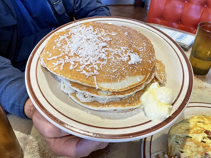 Coconut pancakes dusted with powdered sugar and shredded coconut, because sometimes breakfast should feel like a tropical vacation.
