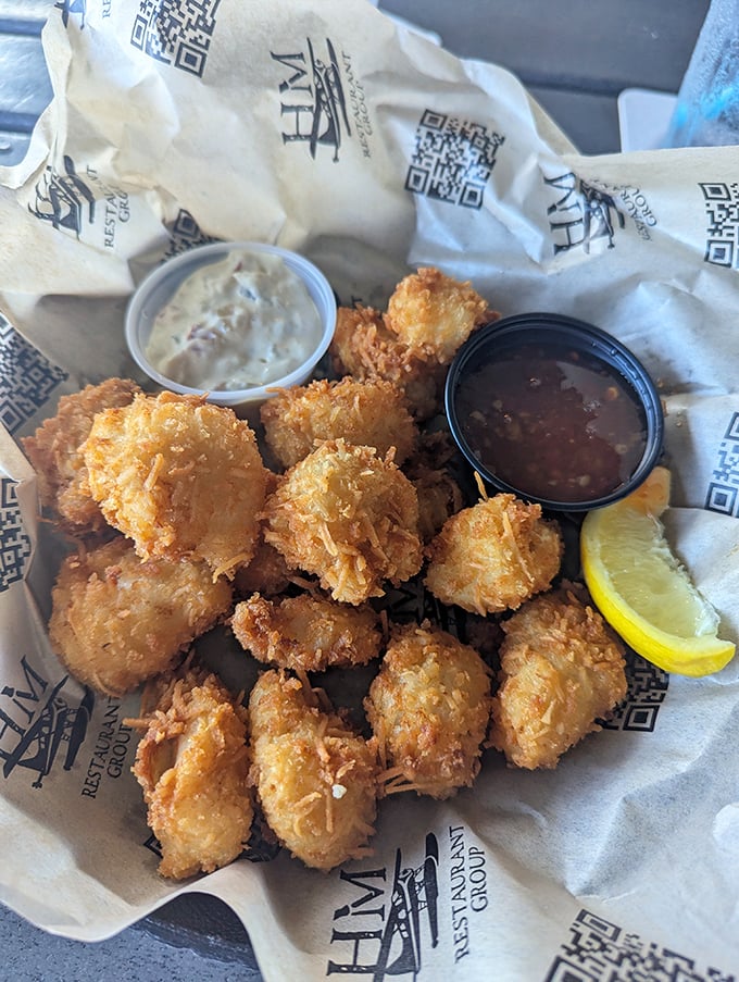 Coconut-crusted grouper cheek bites – the seafood equivalent of finding money in your pocket. These golden nuggets prove the best things come in small, crispy packages.