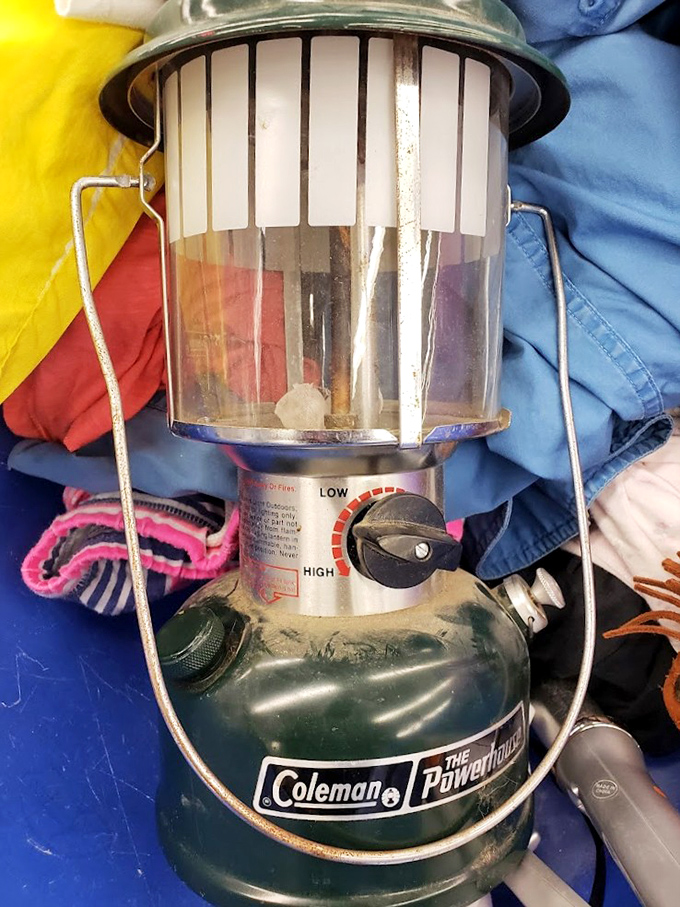 Vintage Coleman lantern nestled among textiles&mdash;perfect for your next camping trip or creating that rustic ambiance on your patio.