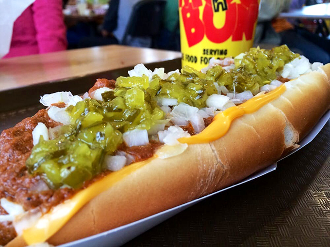 A Coney dog dressed to the nines with onions and relish, ready for its close-up.