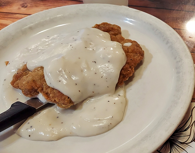 Country fried steak swimming in creamy pepper gravy&mdash;the breakfast equivalent of a warm hug from someone who truly understands comfort food. 