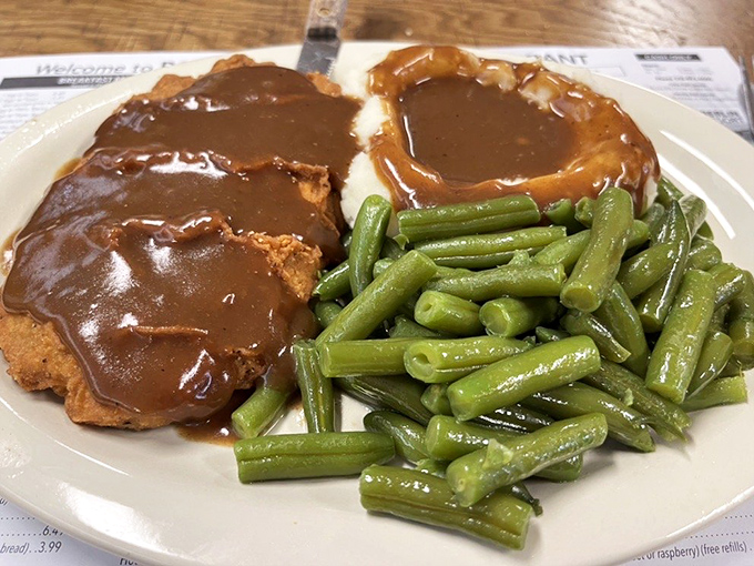 Country fried steak with green beans—proof that heaven exists on a plate, especially when that crispy exterior gives way to tender meat beneath rich gravy.