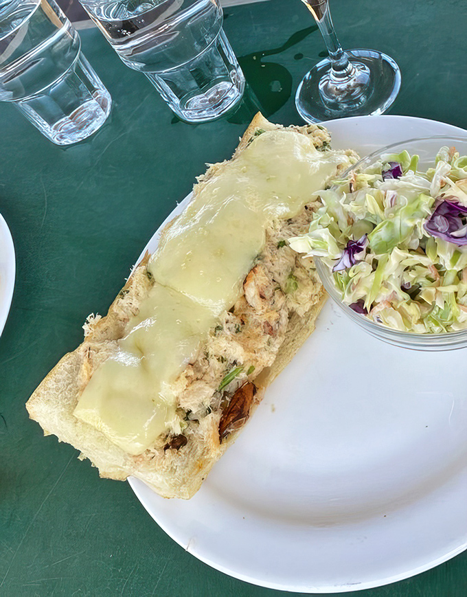 Crab sandwich perfection &ndash; sweet meat, melted cheese, and coleslaw on the side. The ocean called; it wants to know why you're smiling.