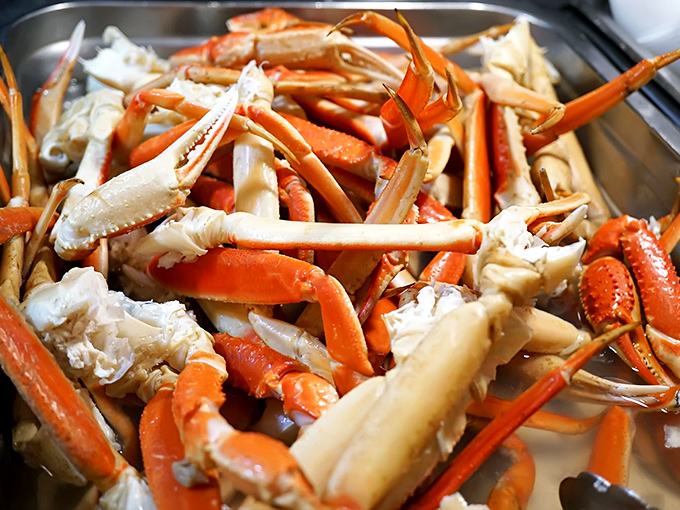 Snow crab legs cascading like edible confetti, proving that sometimes the best things come with their own built-in utensils.