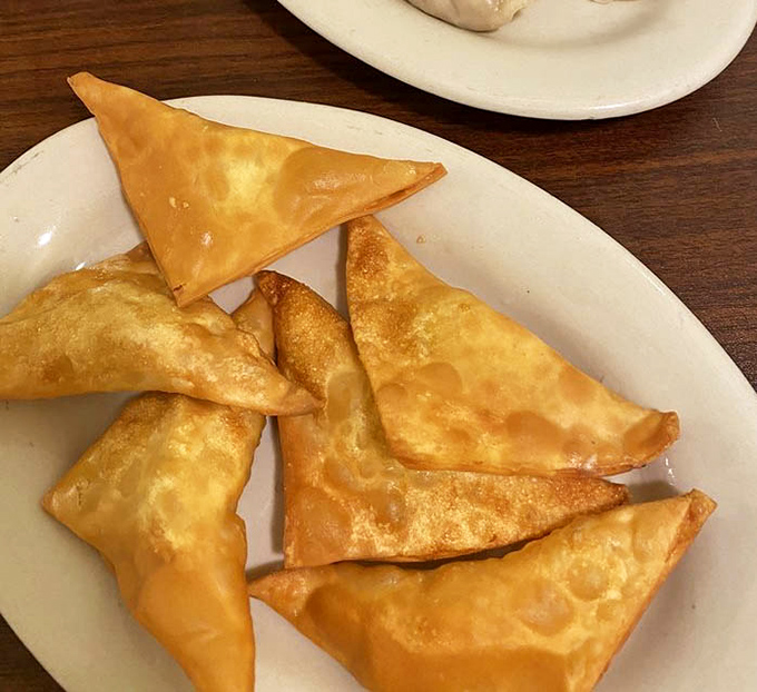 Crab rangoon triangles fried to golden perfection. These crispy pockets of creamy goodness could start a religion.