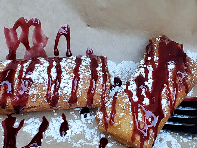 Deep-fried cheesecake drizzled with raspberry sauce&mdash;because regular cheesecake wasn't indulgent enough. The powdered sugar snowfall is just showing off at this point.