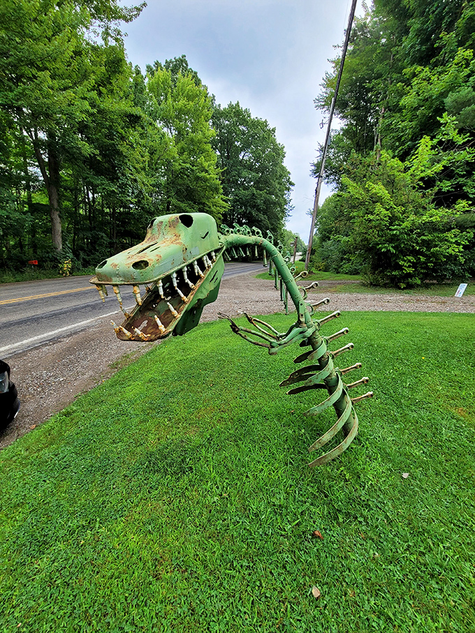 Jaws that could crunch a compact car! This green dinosaur skeleton lurks roadside, stopping traffic with its toothy grin and prehistoric presence.