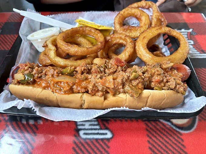Hot dog architecture at its finest! This loaded masterpiece with crispy onion rings makes ballpark franks look like they're not even trying.