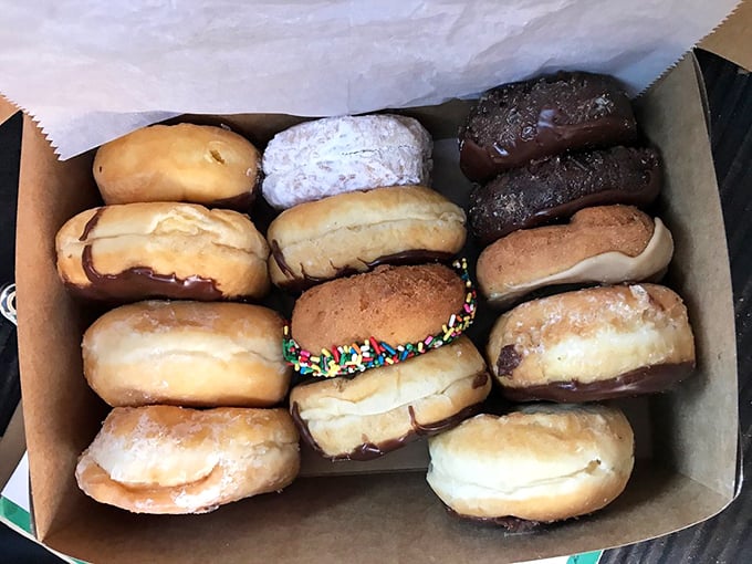 A dozen reasons to smile, neatly arranged in a box. The sprinkle-topped donut in the middle is practically winking at you.