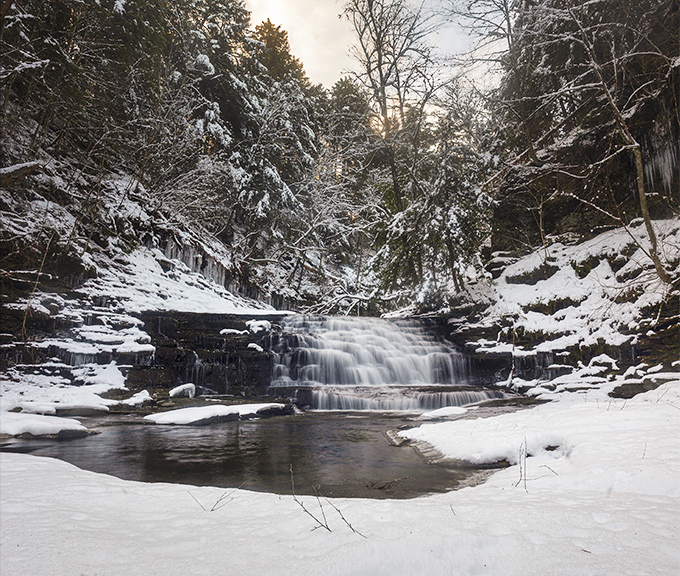 Winter transforms the falls into a crystalline sculpture garden where every icicle tells a story of patience and persistence.