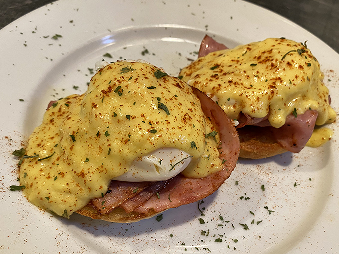 Eggs Benedict gets the Southern treatment here &ndash; perfectly poached eggs perched atop ham on English muffins, draped in hollandaise that whispers "take your time."