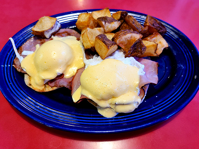 Eggs Benedict perfected: golden hollandaise cascading over ham and English muffins like a sunrise over the Blue Ridge Mountains.