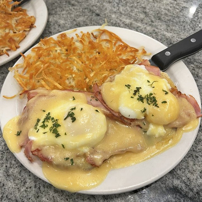 Hollandaise cascading over poached eggs like a delicious yellow waterfall&mdash;breakfast engineering at its finest.