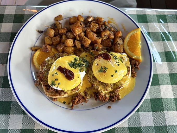 Eggs Benedict perfection: two golden orbs perched atop English muffins, draped in hollandaise that cascades like a buttery waterfall of happiness.