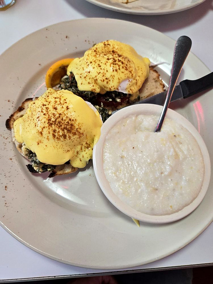Eggs Benedict that defies gravity—perfectly poached eggs wearing hollandaise jackets, perched on English muffins with a side of grits for Southern cred.