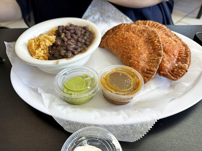 An empanada that would make your abuela proud sits alongside classic rice and beans. Culinary diplomacy at its most delicious.
