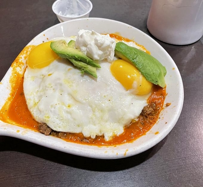 These eggs aren't just sitting on enchiladas&mdash;they're crowning them like royalty, with avocado slices as the royal attendants.