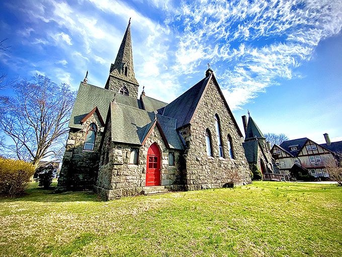 This stone church with its striking red door isn't just architectural eye candy—it's a 19th-century masterpiece against a perfect blue sky.