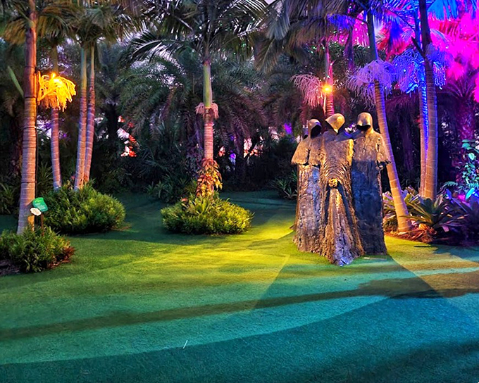 As evening falls, colorful lighting transforms the hooded figures into mystical beings, creating a magical atmosphere that feels worlds away from Orlando's tourist corridors.