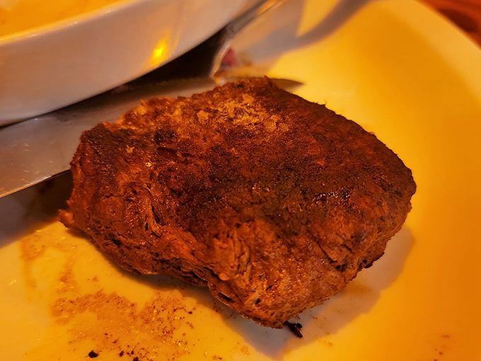 This isn't just a steak; it's a meditation on perfection. The filet's seared exterior gives way to a center that practically melts on sight.