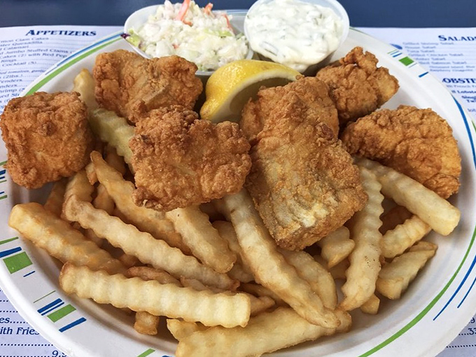 Fish and chips done right&mdash;crispy, golden batter protecting flaky white fish, with crinkle-cut fries standing by for dipping duty. A squeeze of lemon seals the deal.