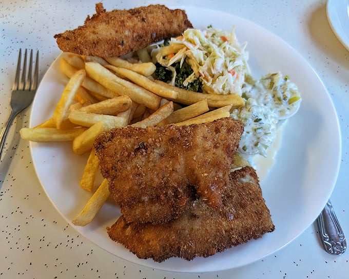 Golden-fried fish with a crackling crust that shatters at first bite, served with the kind of fries that disappear one by one.