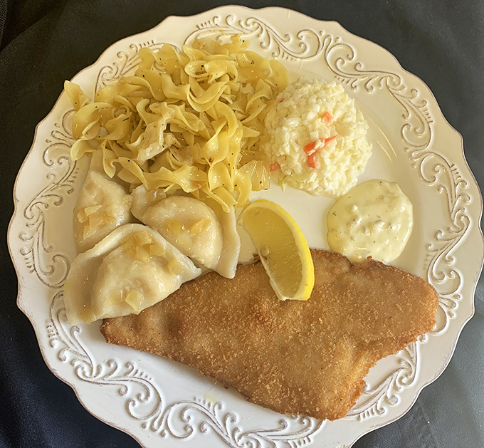 A Polish feast fit for royalty: golden-fried fish, buttery pierogi, and egg noodles. The elegant plate says "fine dining" while the portions say "we want you happy."