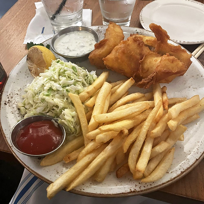 Fish and chips done right is culinary poetry. Golden-battered fish with a satisfying crunch gives way to flaky perfection inside.