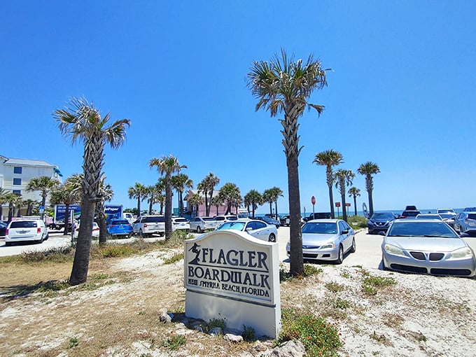 The Flagler Boardwalk sign stands sentinel over paradise parking, where finding a spot feels like winning a minor lottery any day after 10am.